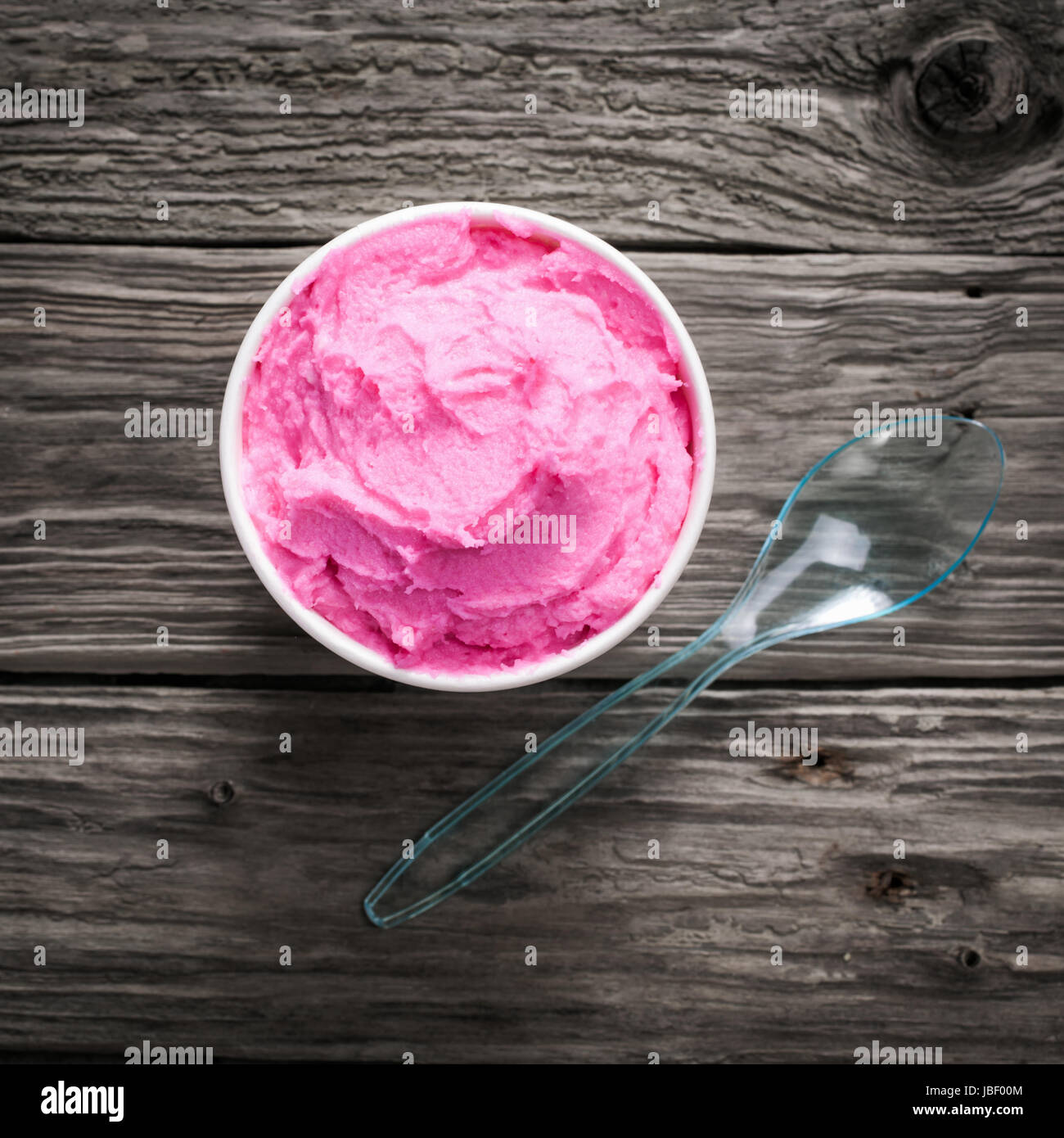 Overhead view of a tub of delicious refreshing pink ice cream with a ...