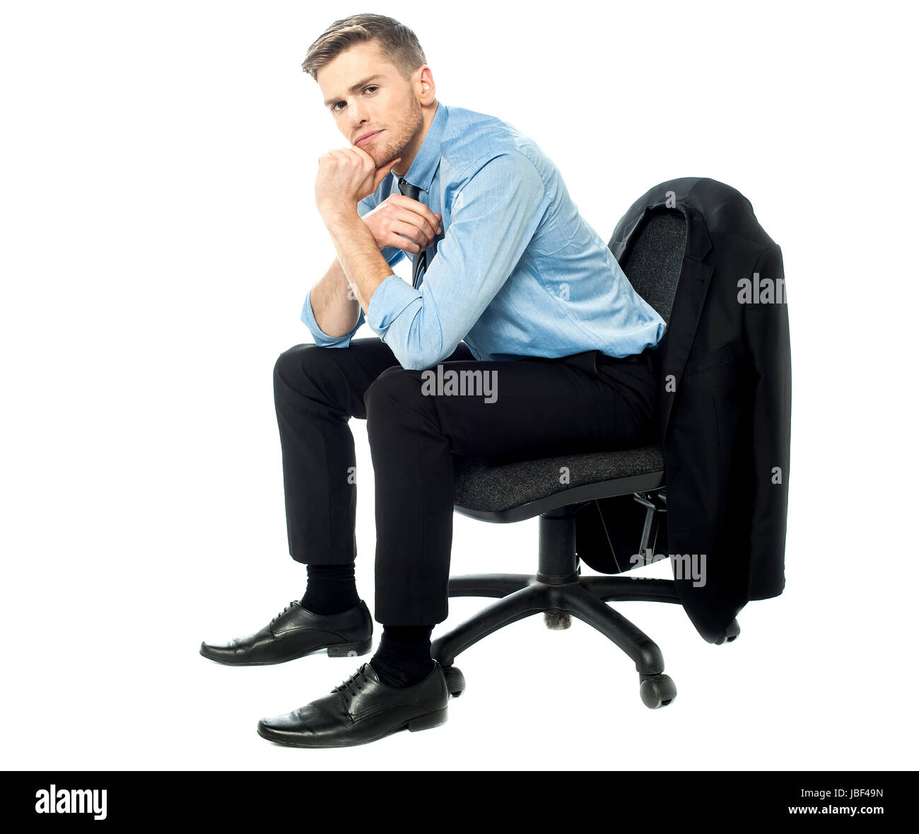 Corporate guy sitting on the chair and thinking Stock Photo - Alamy