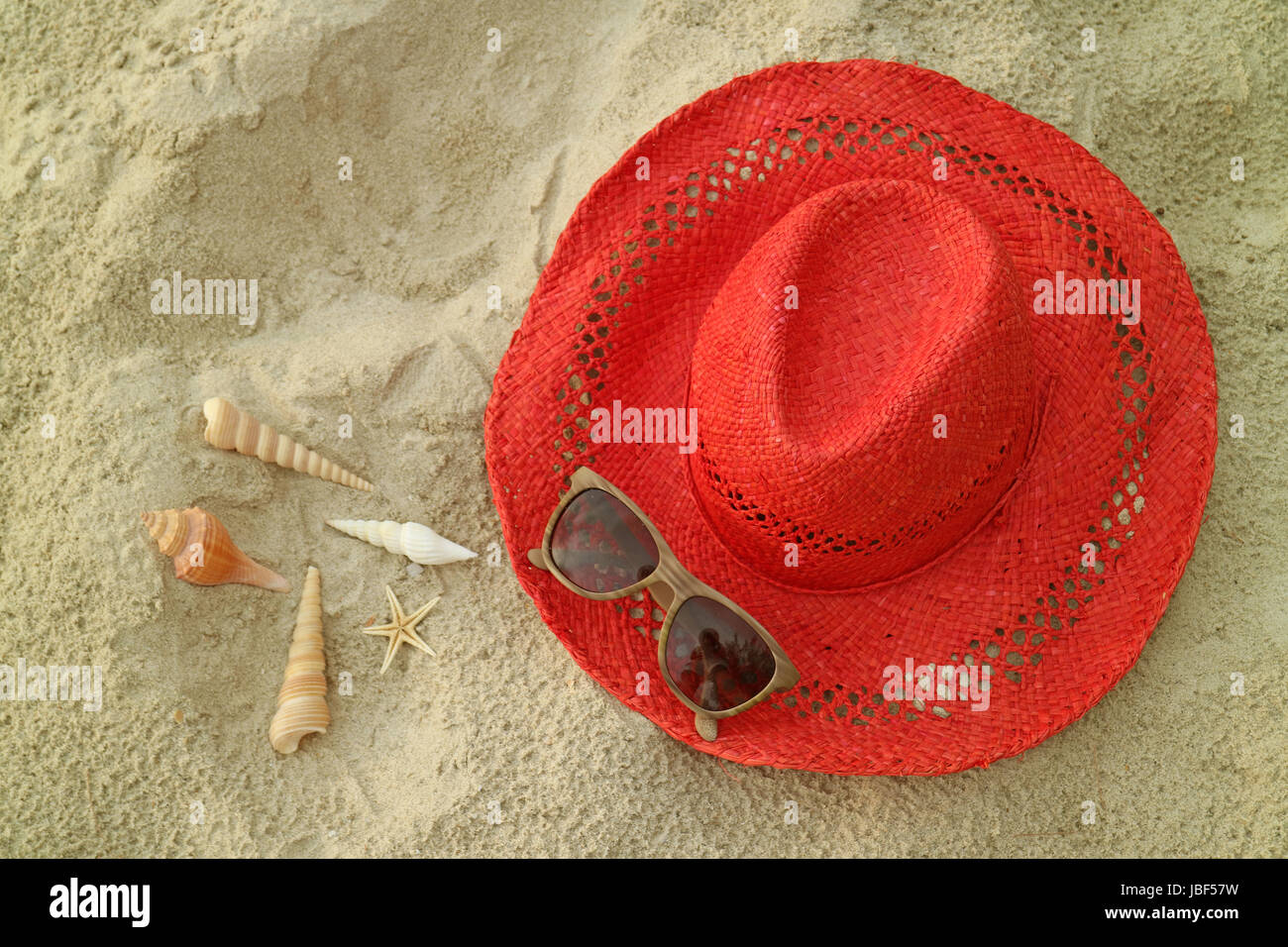 Red straw hat and brown sunglasses on the sand beach with many types of ...