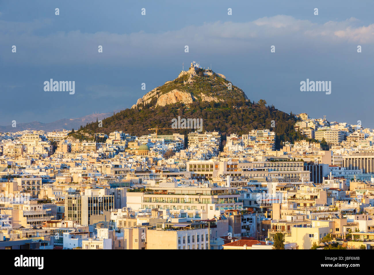 Athens, Greece city skyline with Lycabettus hill against a cloudy sky ...