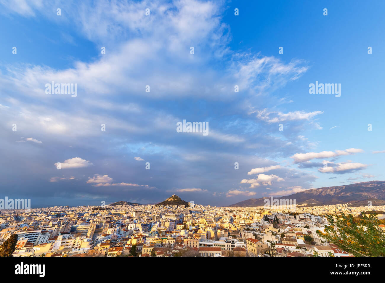 Athens, Greece city skyline with Lycabettus hill against a cloudy sky ...