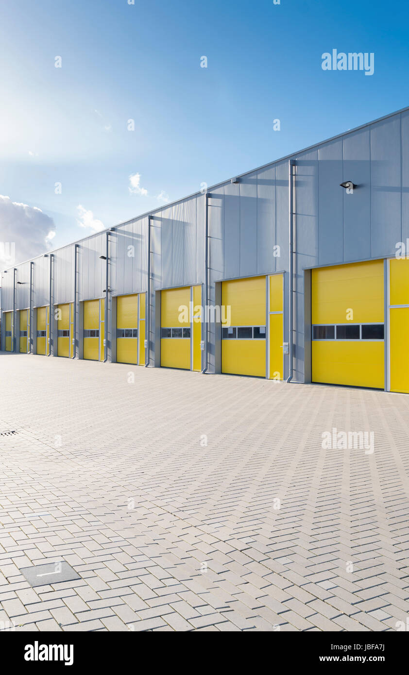 exterior of a commercial warehouse with yellow roller doors Stock Photo ...