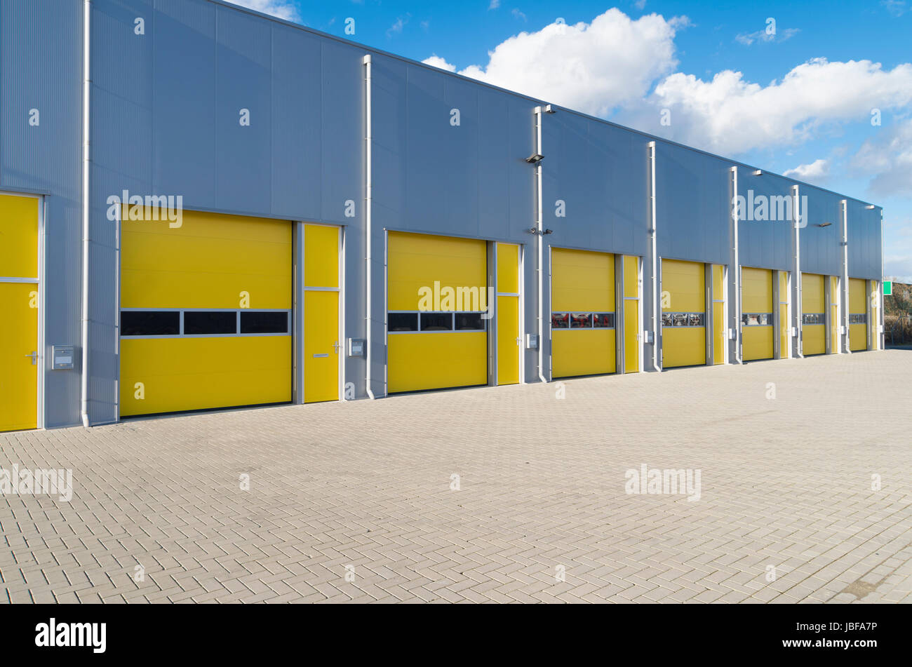exterior of a commercial warehouse with yellow roller doors Stock Photo ...