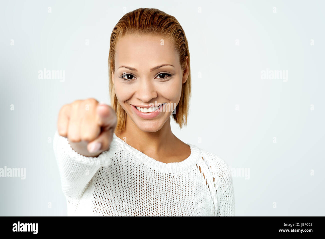 Attractive young model pointing towards camera Stock Photo - Alamy