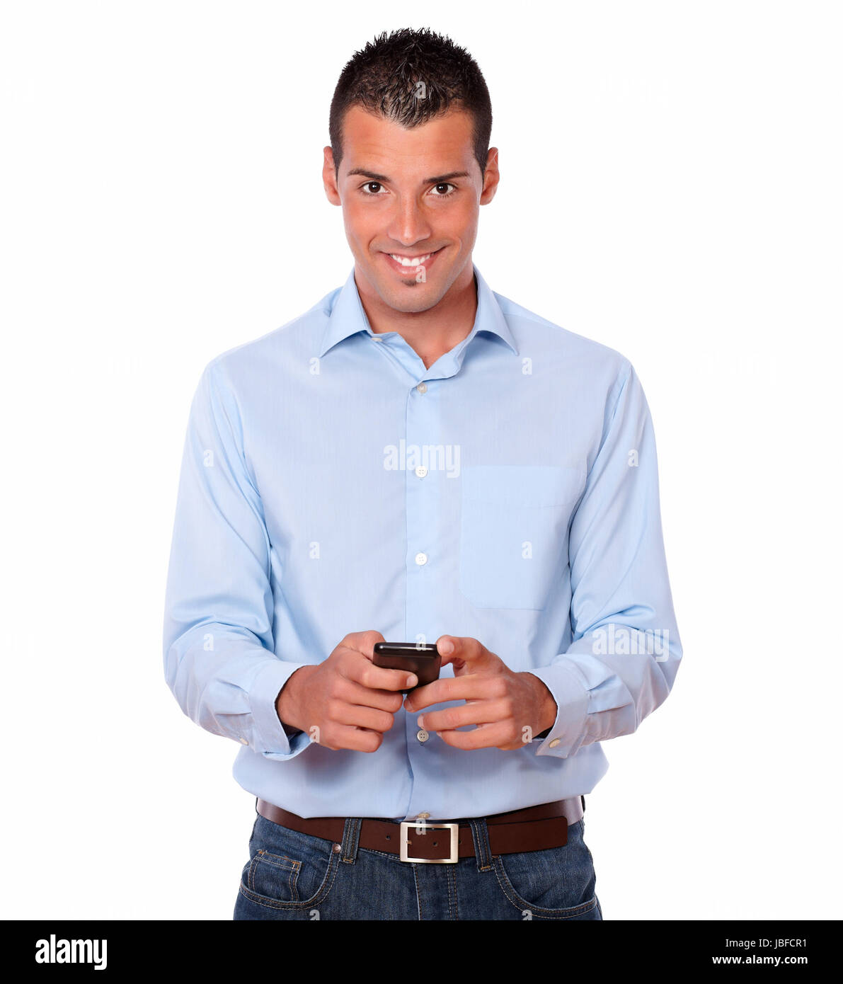 Portrait of a gorgeous young man on blue shirt and jeans texting with ...