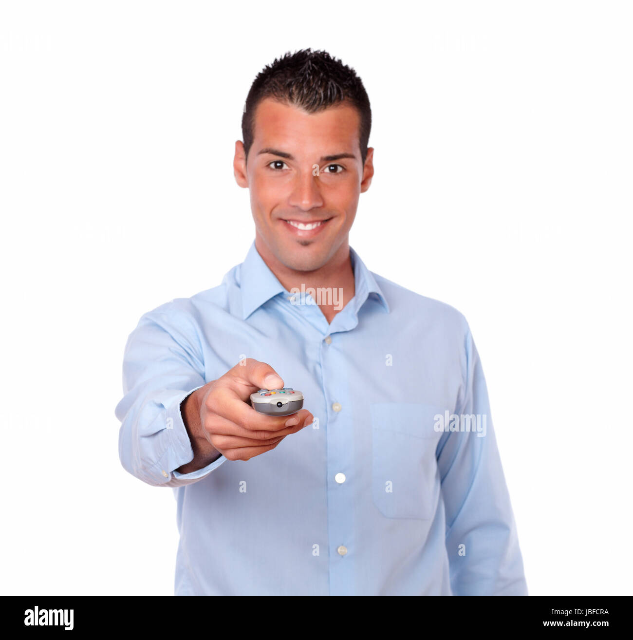 Portrait of an attractive guy on blue shirt pointing with remote ...