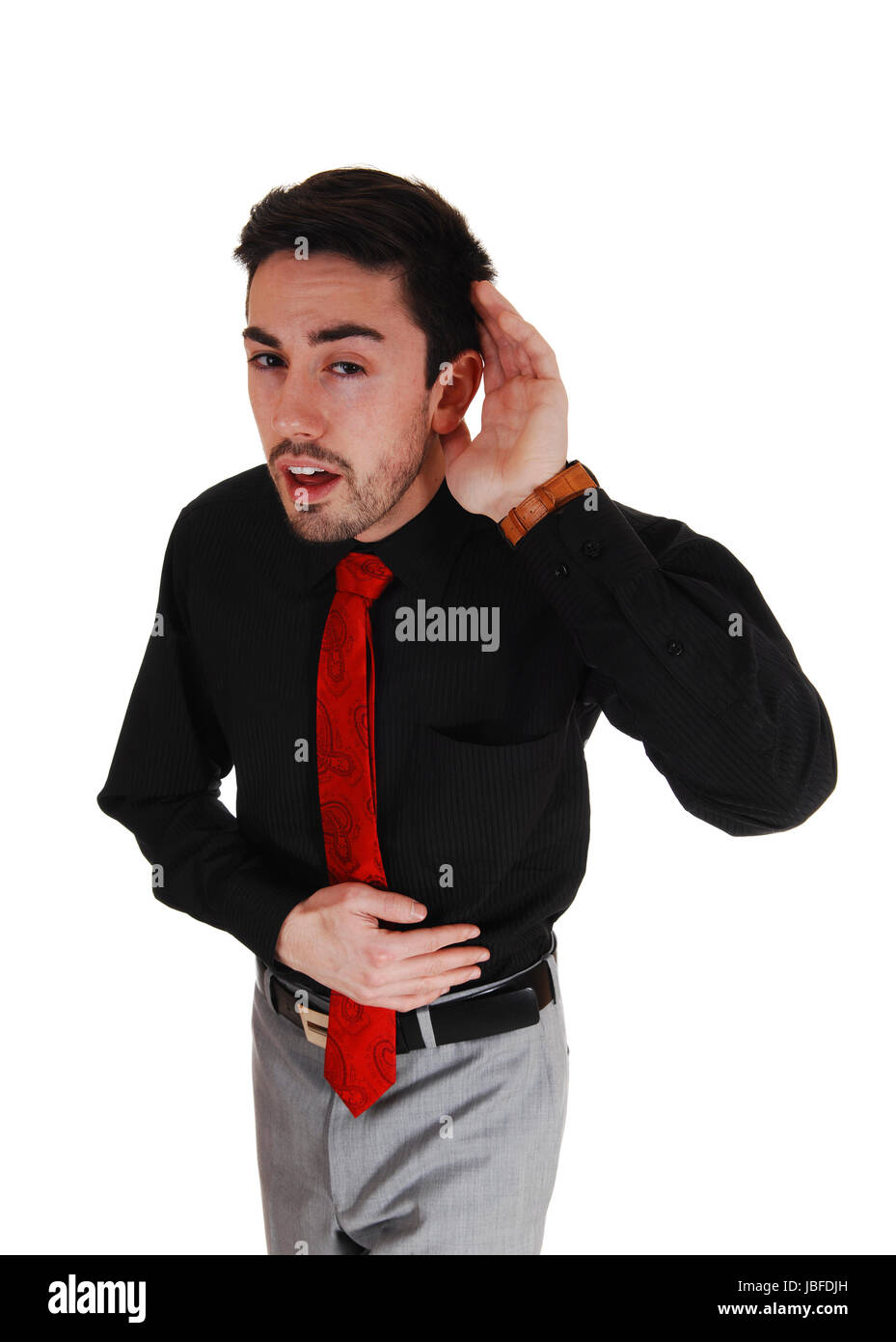 A young businessman holding his hand behind his ear, he can not hear to ...