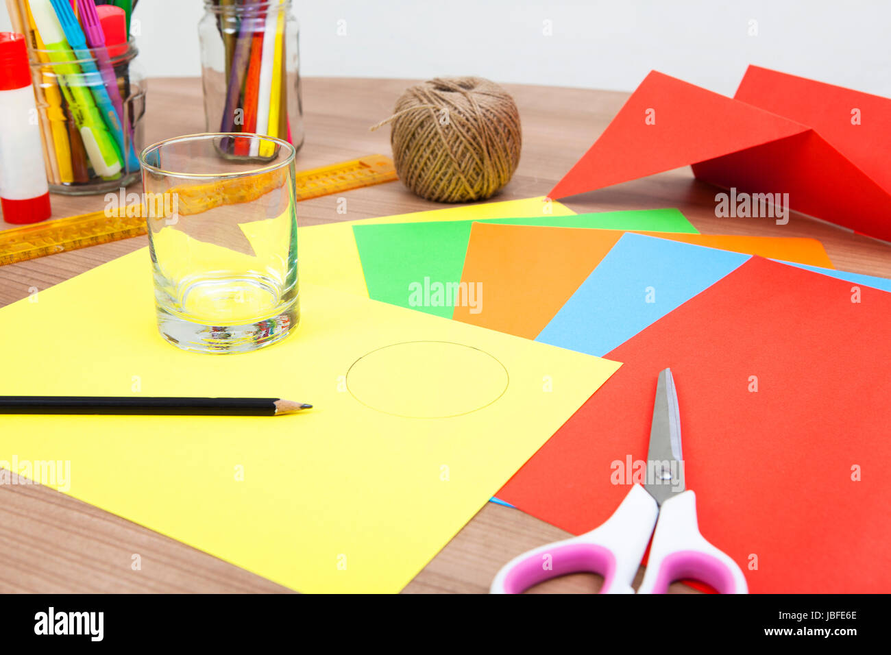 colored paper lying on a table. With a glass circles are painted and ...