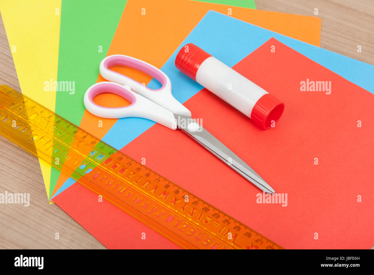 Paper with ruler glue and scissors on a wooden table, close-up Stock ...