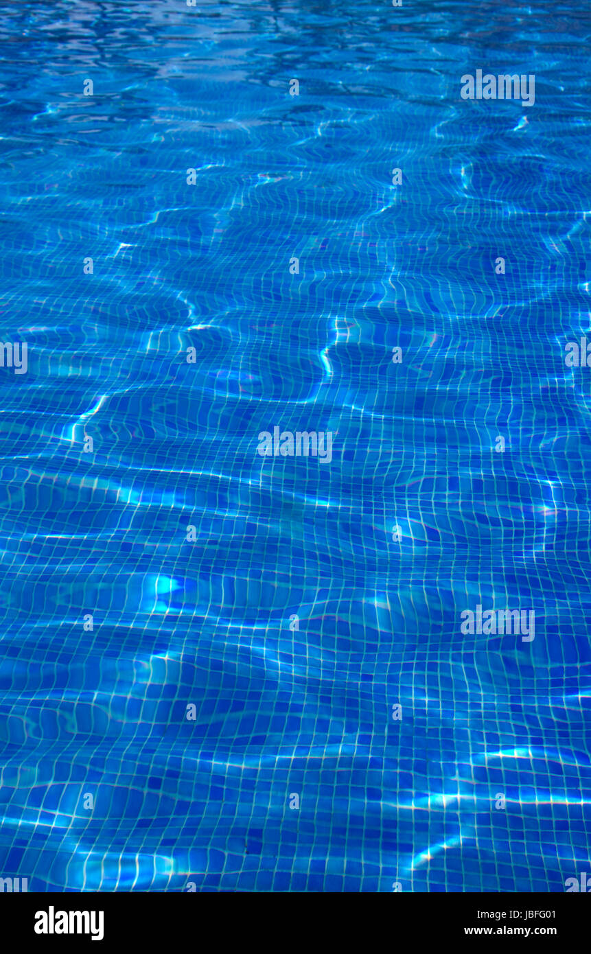 Blue pool water with sun reflections Stock Photo - Alamy