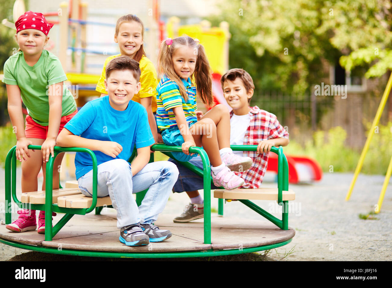 Image of cute friends having fun on carousel outdoors Stock Photo - Alamy