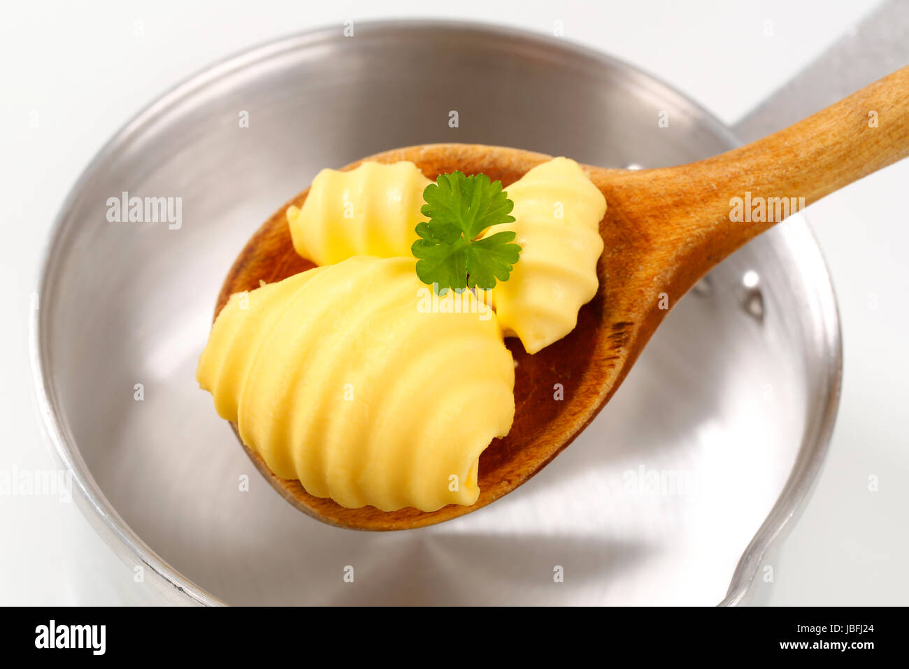 Butter curls on wooden spoon and saucepan Stock Photo - Alamy