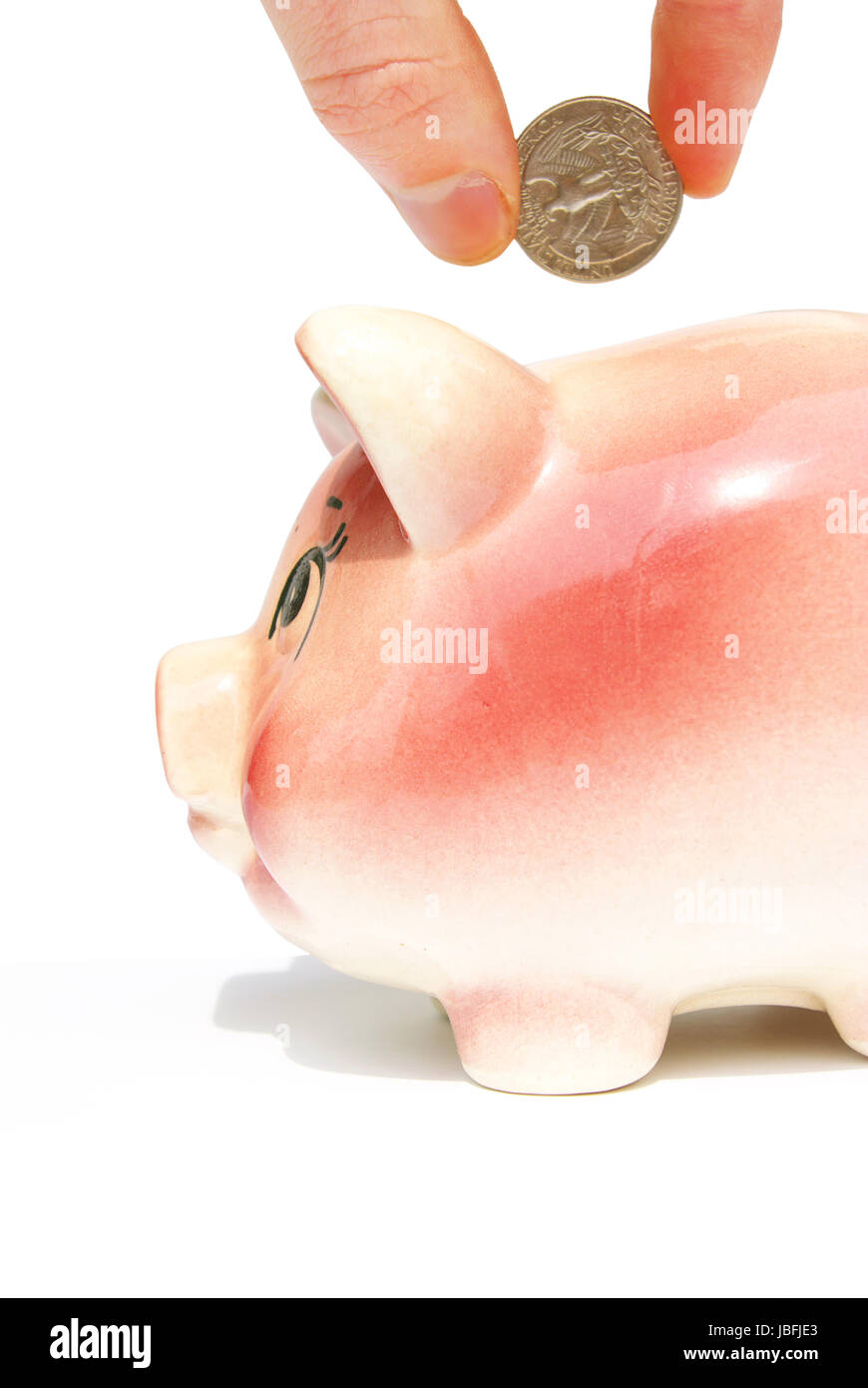 Hand inserting coin into piggy bank isolated on white Stock Photo - Alamy