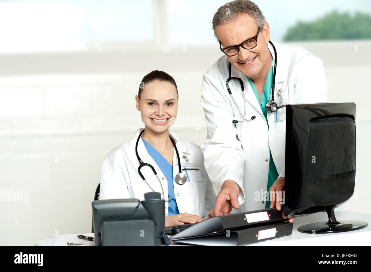 Two physicians around the table at work Stock Photo - Alamy