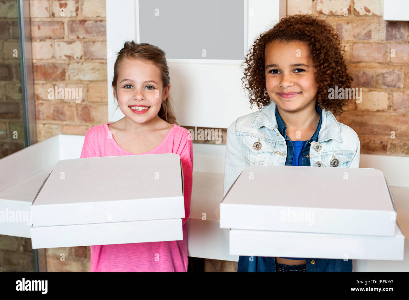 Attractive little girls posing with pizza boxes Stock Photo - Alamy