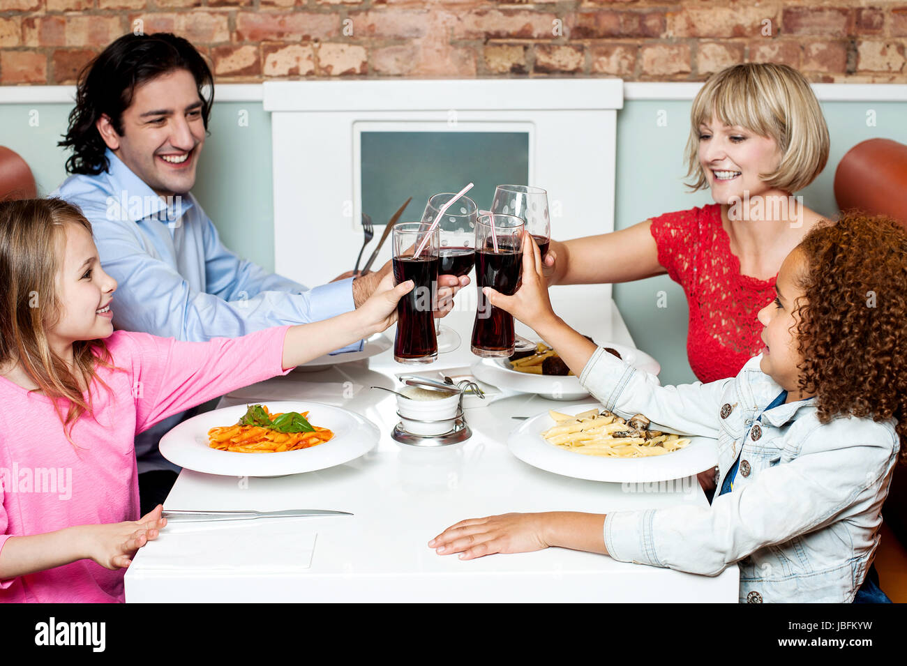 Cheerful family of four celebrating, Cheers! Stock Photo - Alamy