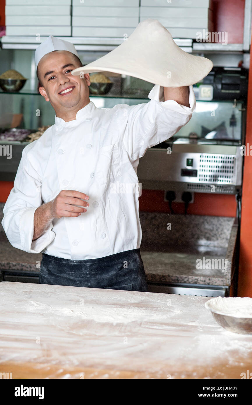 Skilled male chef throwing pizza base dough Stock Photo - Alamy