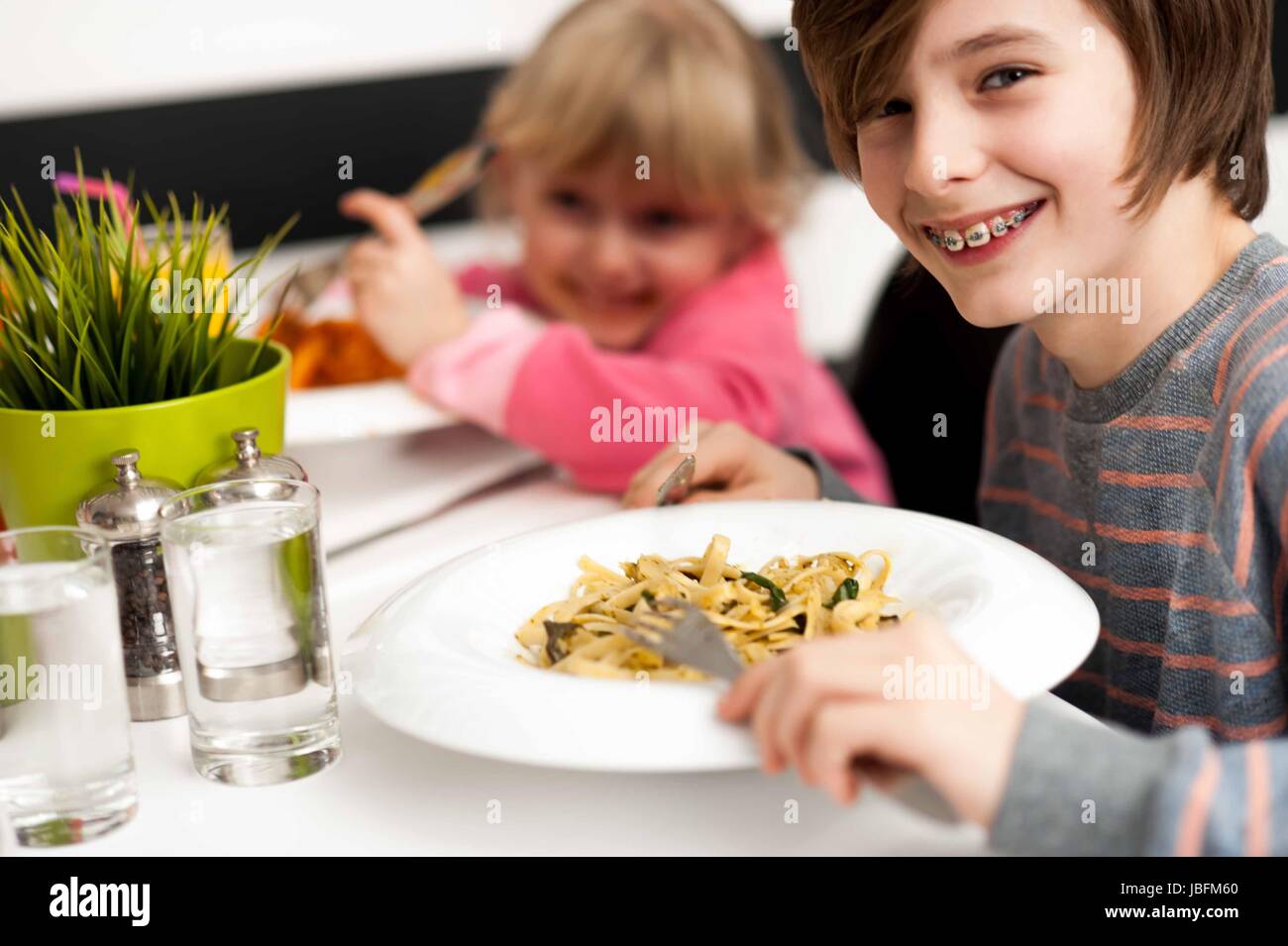 Siblings enjoying meal in a restaurant Stock Photo - Alamy