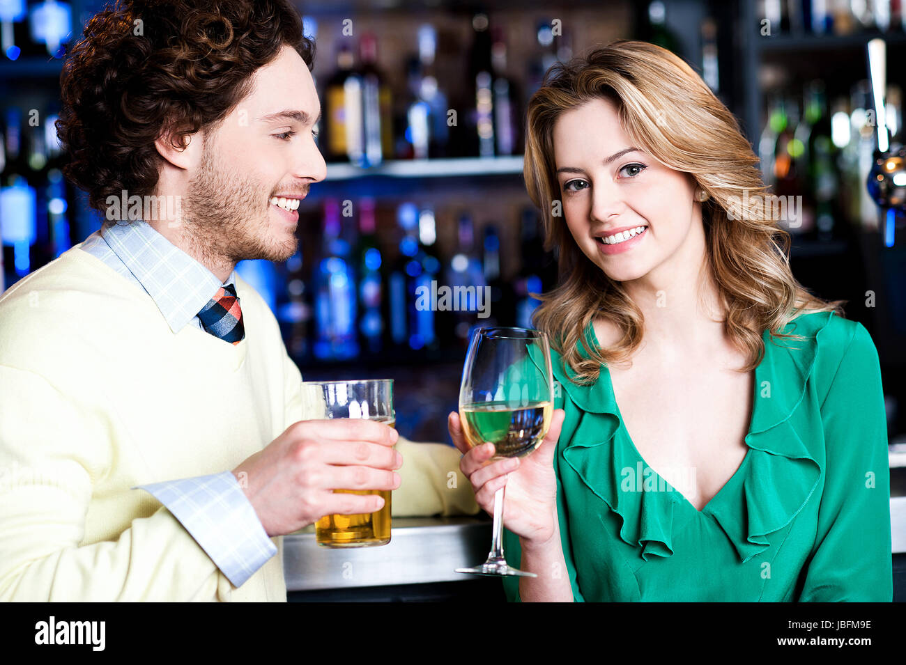 Cheerful young couple having cocktail at restaurant bar Stock Photo - Alamy