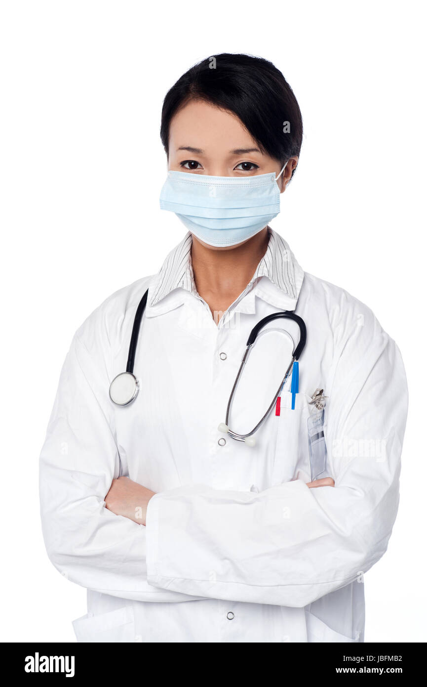 Young female physician covering her face with surgical mask Stock Photo ...