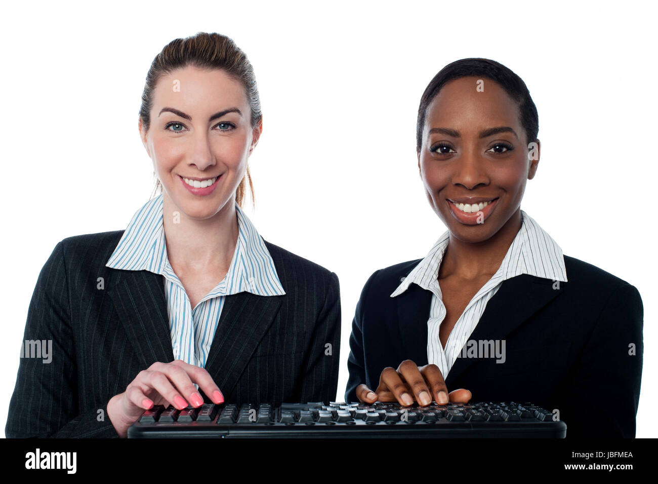 Two female executives typing on keyboard Stock Photo - Alamy