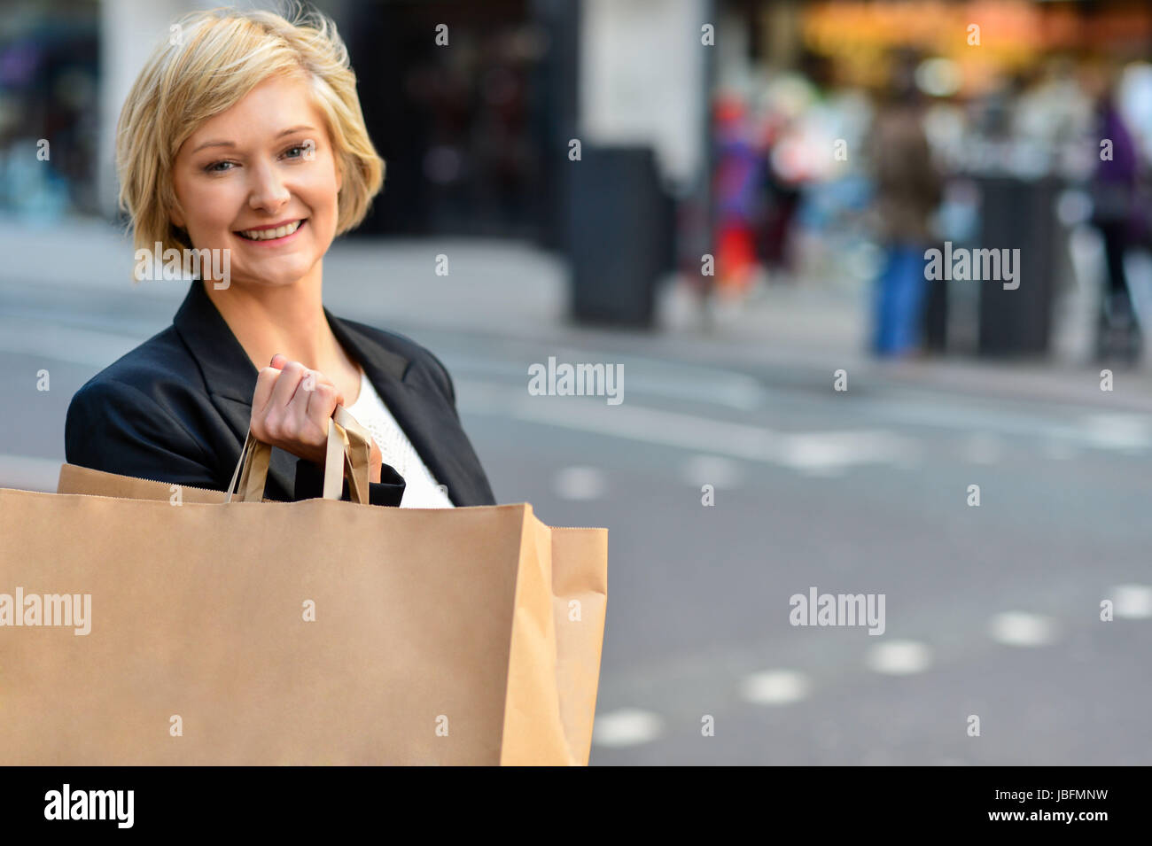 Pretty corporate lady carrying shopping bag Stock Photo - Alamy
