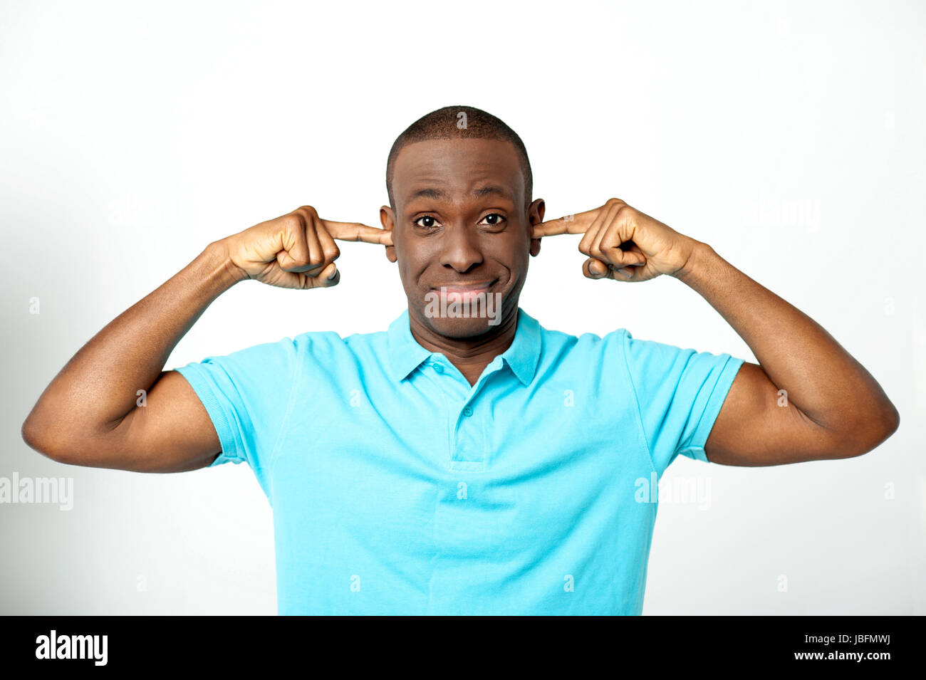 Handsome guy closing ears with her fingers Stock Photo - Alamy