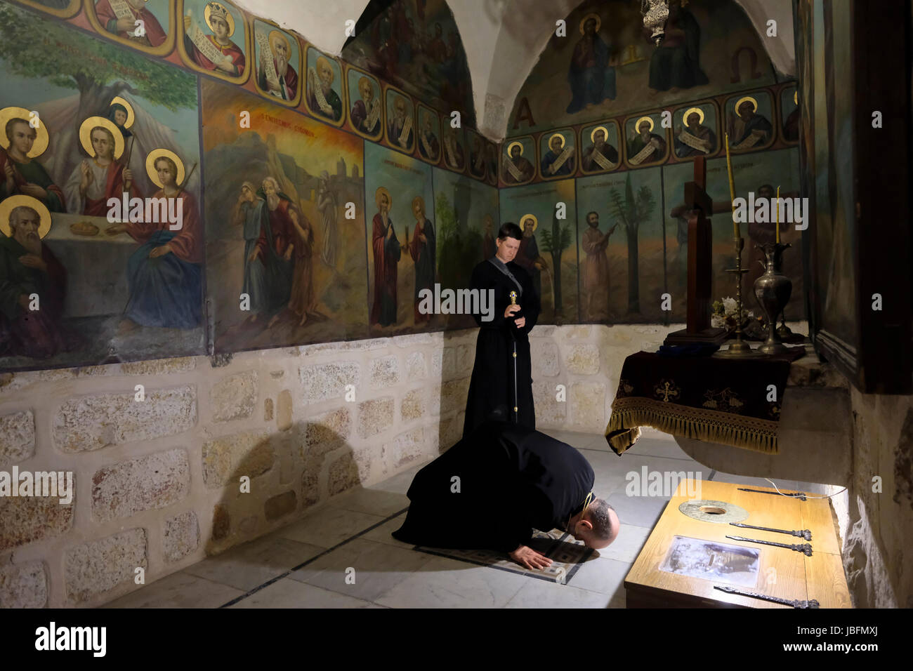 Eastern Orthodox priests praying at the room of the Holy tree inside ...