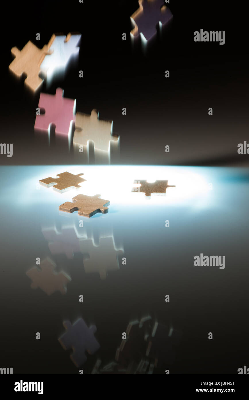 Falling puzzle pieces.Backlight background Stock Photo - Alamy