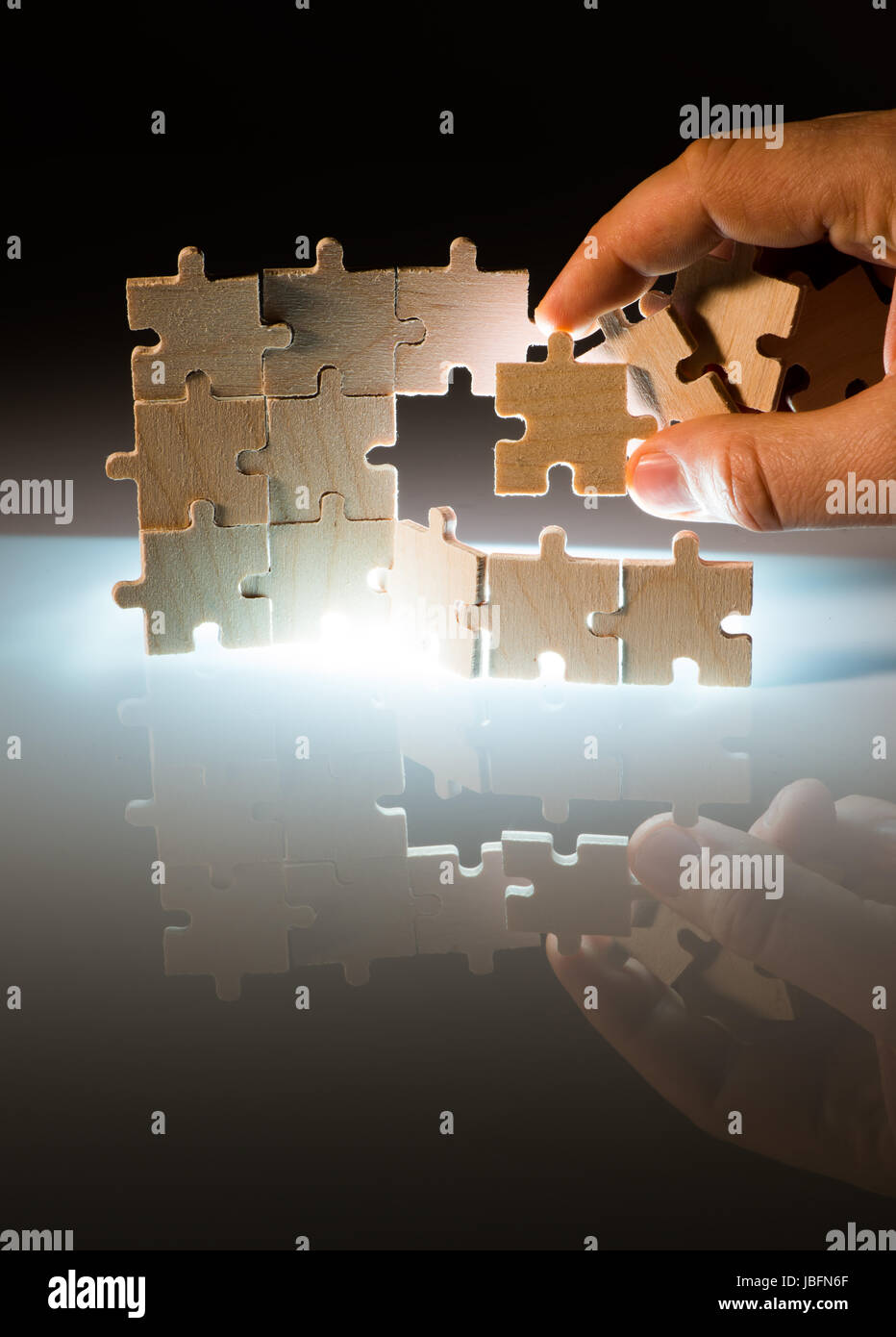Wooden puzzle and backlight background. Vertically stacked parts. Hand ...
