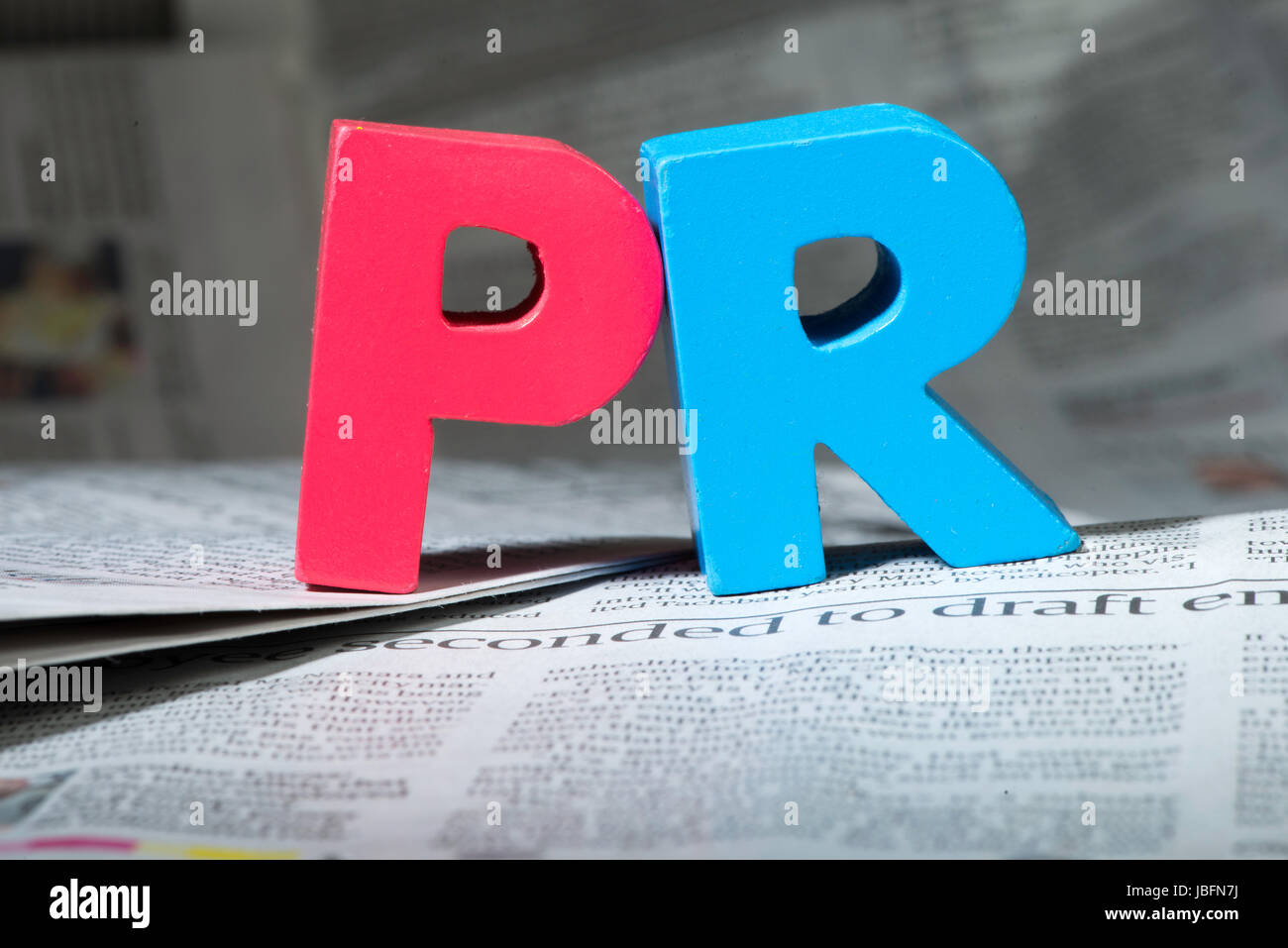 Word PR on newspaper. Wooden letters Stock Photo - Alamy