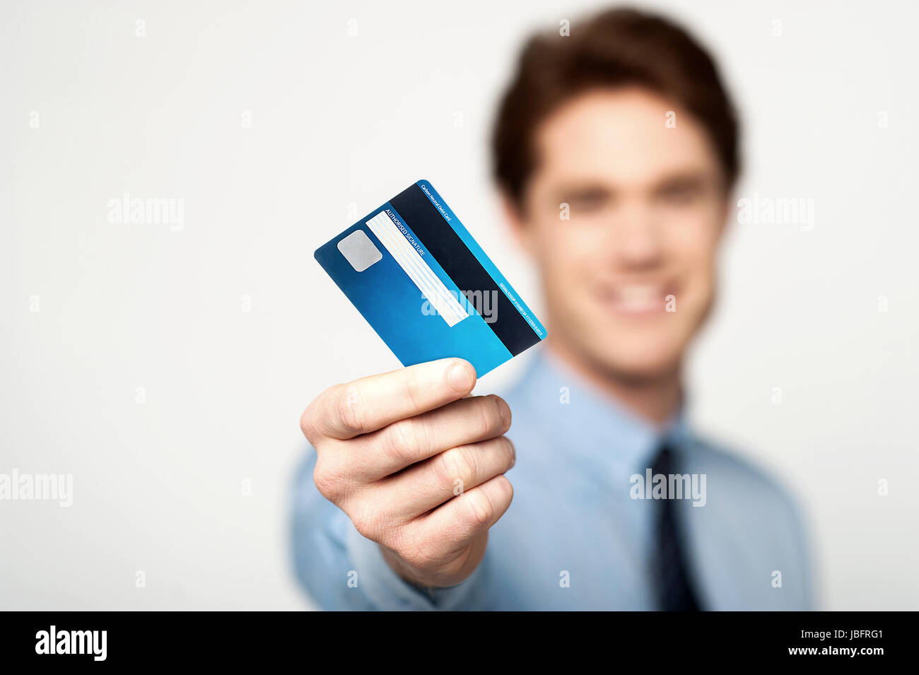 Young corporate guy showing his debit card Stock Photo - Alamy
