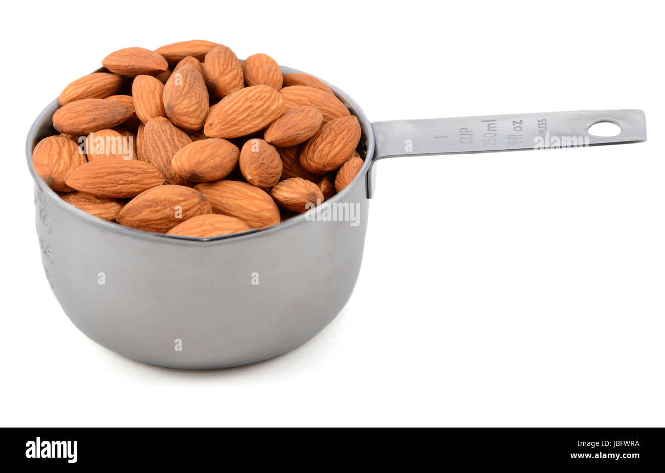 Whole unblanched almonds presented in an American metal cup measure ...