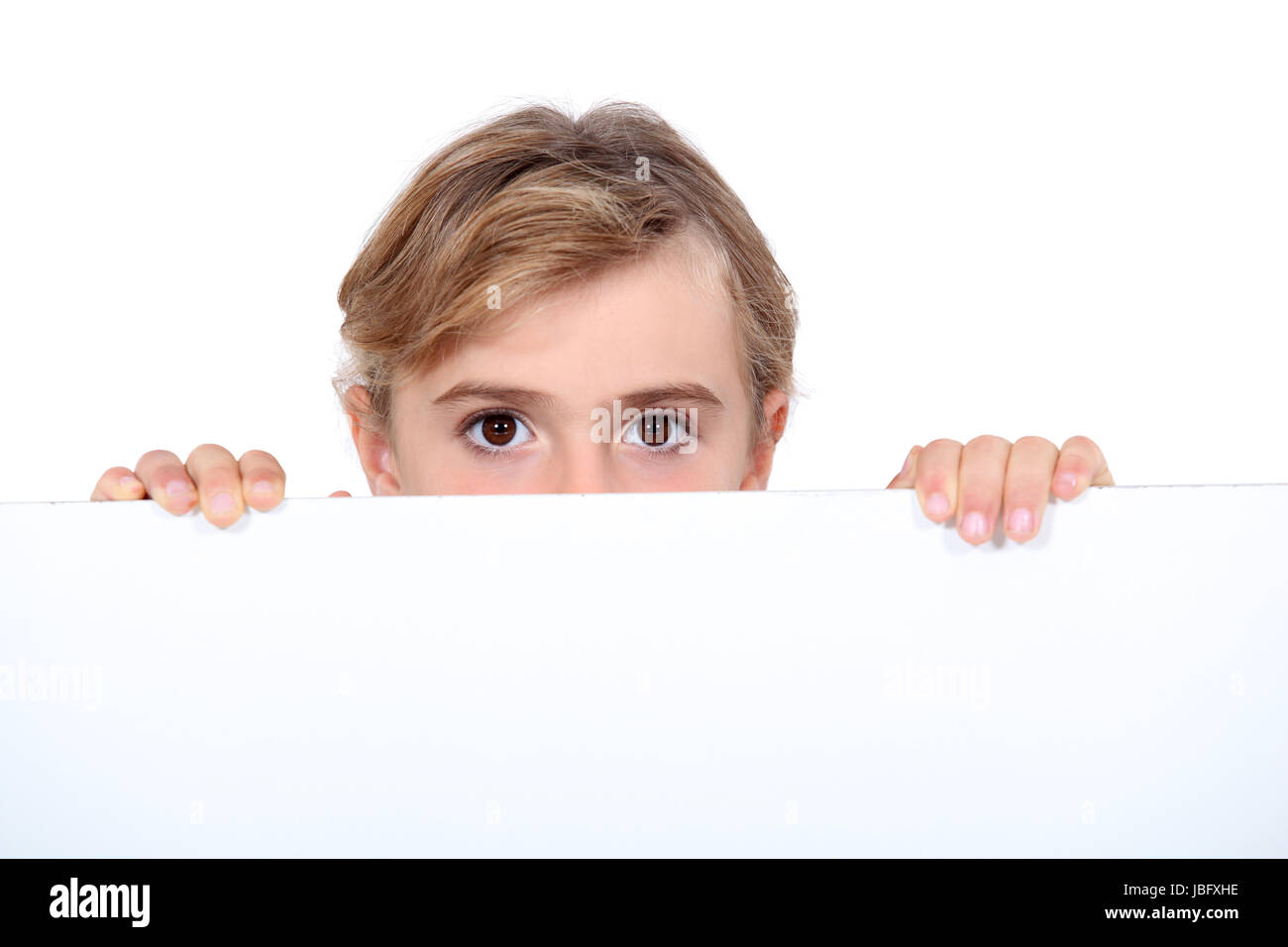 Girl peering over white sign Stock Photo - Alamy
