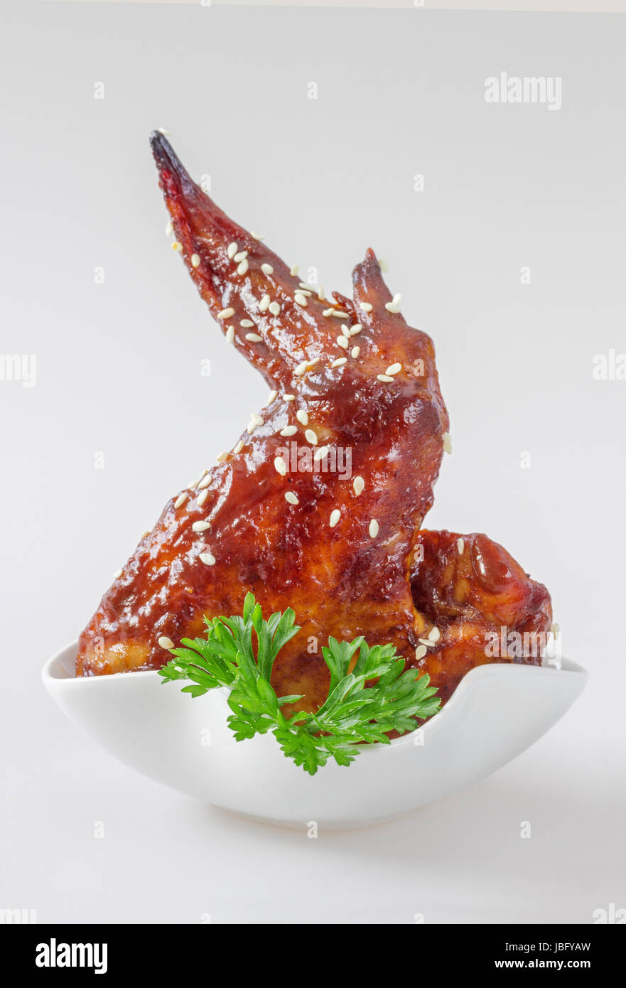 Single BBQ chicken wing in small white bowl, on white background Stock ...
