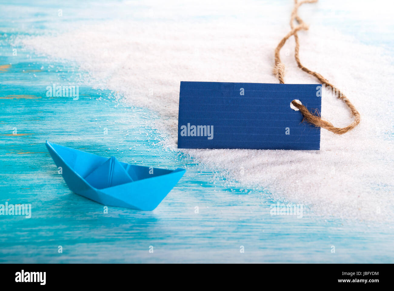 Empty Tag on the Beach with a blue Boat Stock Photo - Alamy