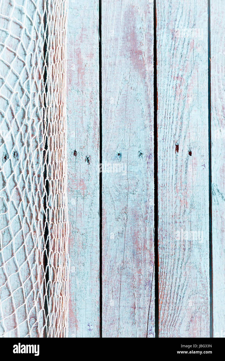 Fishing net former a vertical border on the left of old rustic blue ...
