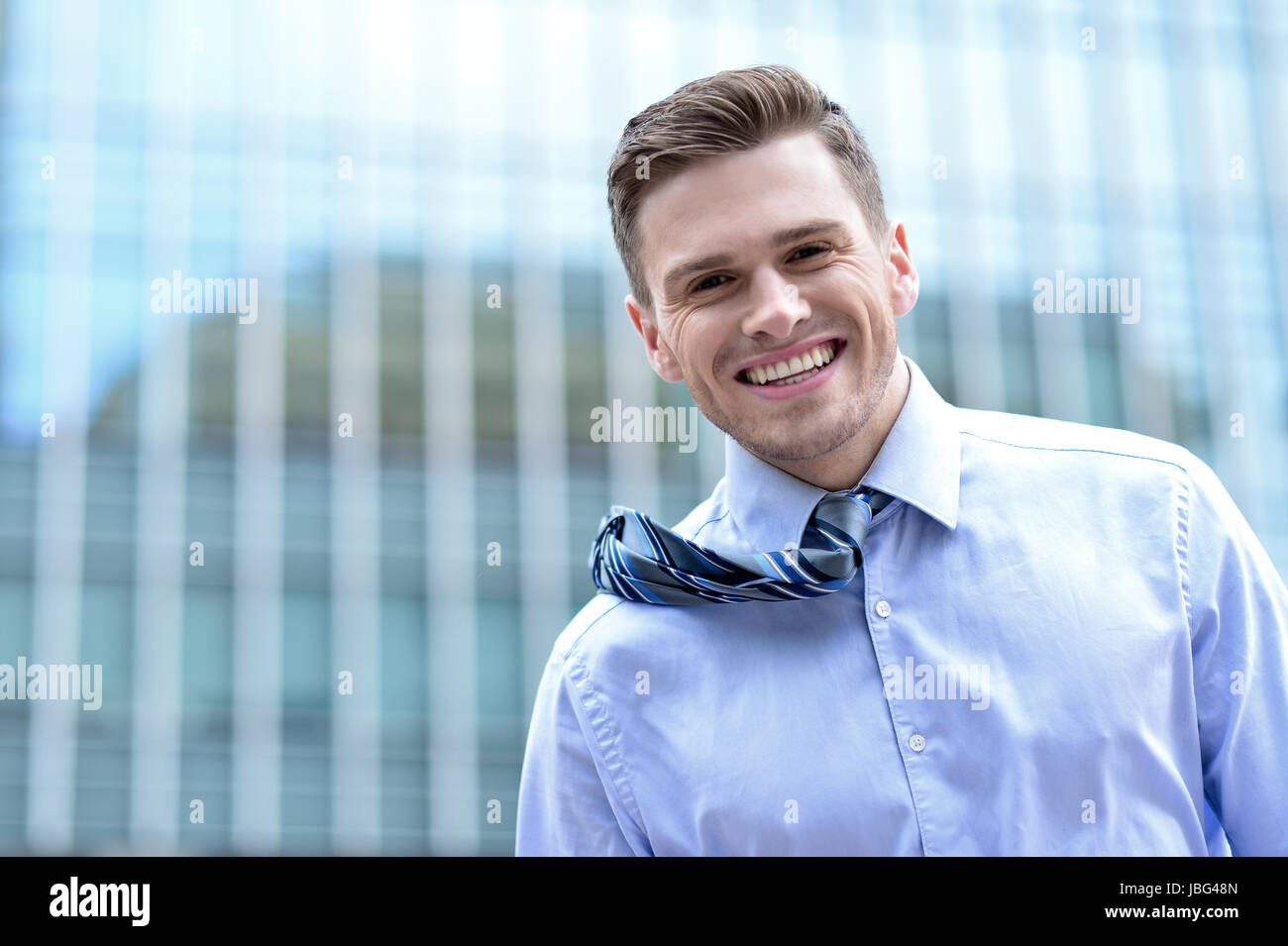 Young businessman standing in front of office building Stock Photo - Alamy