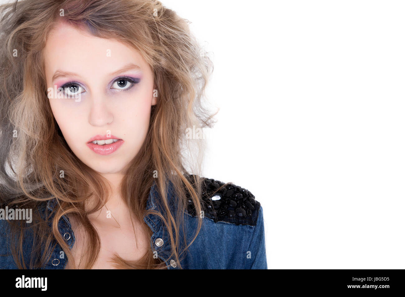 Young tough blond teenage girl with jeans blouse on a white background ...