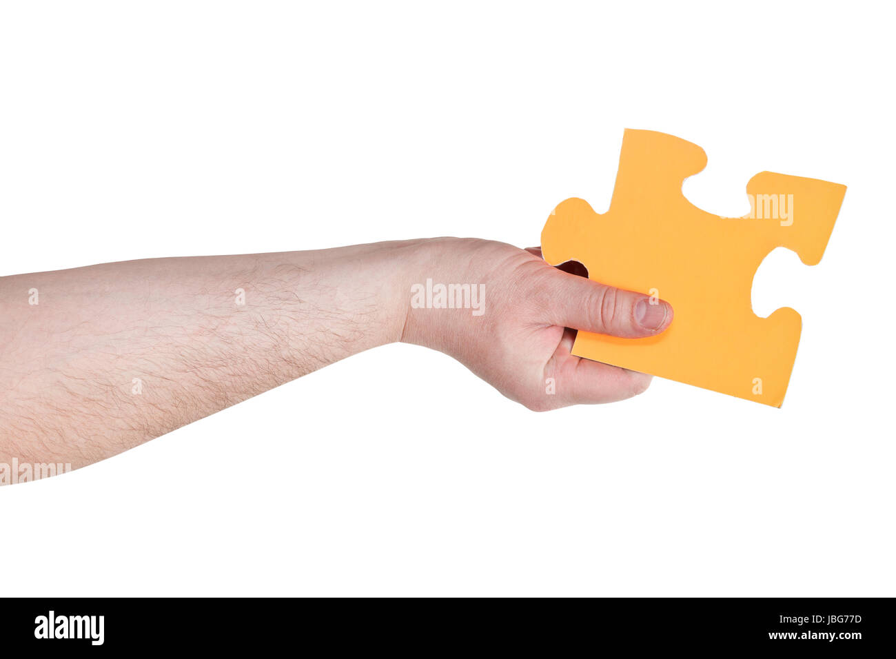 male hand holding big yellow paper puzzle piece isolated on white ...