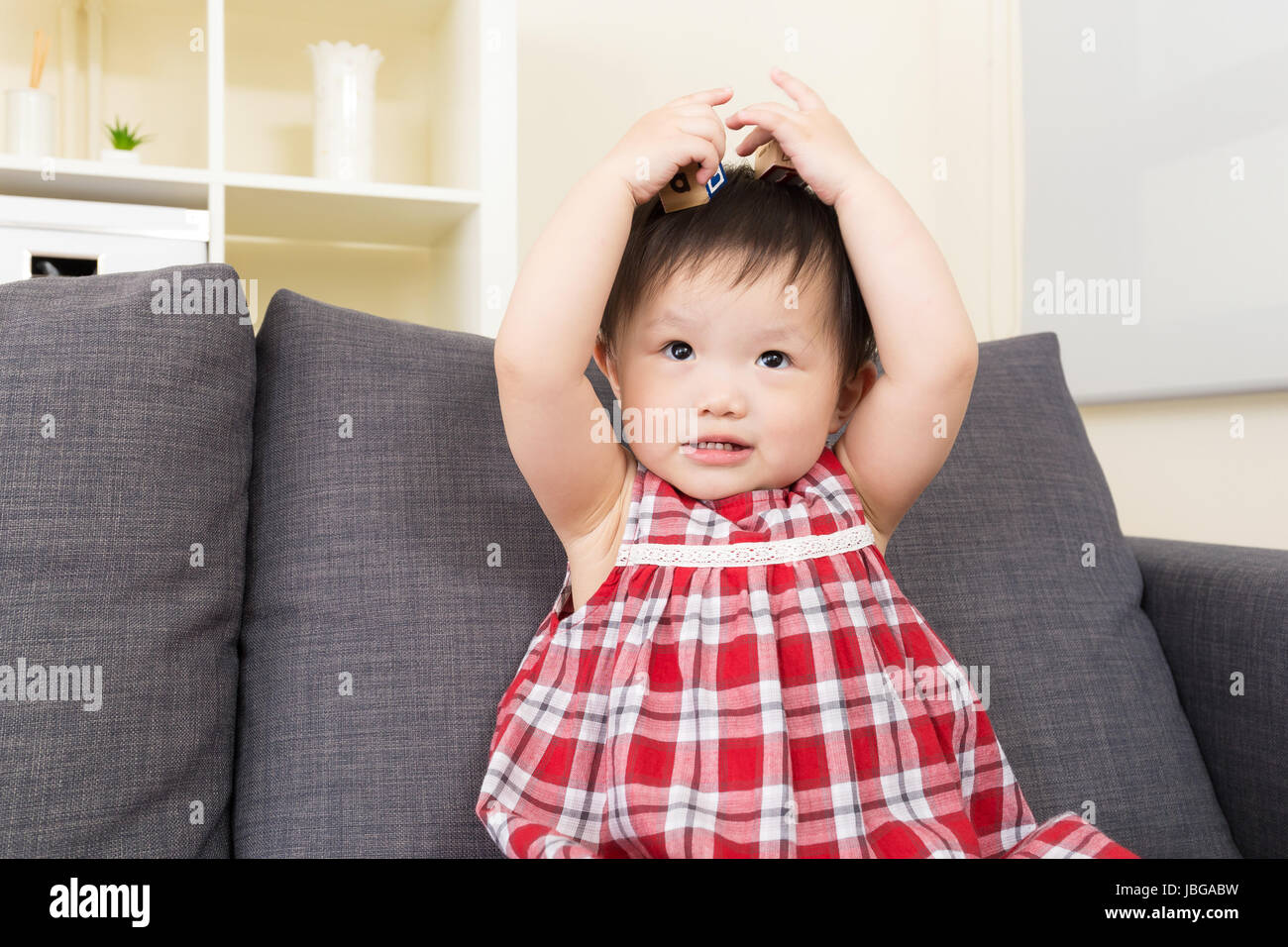Asia baby girl touch her head Stock Photo - Alamy