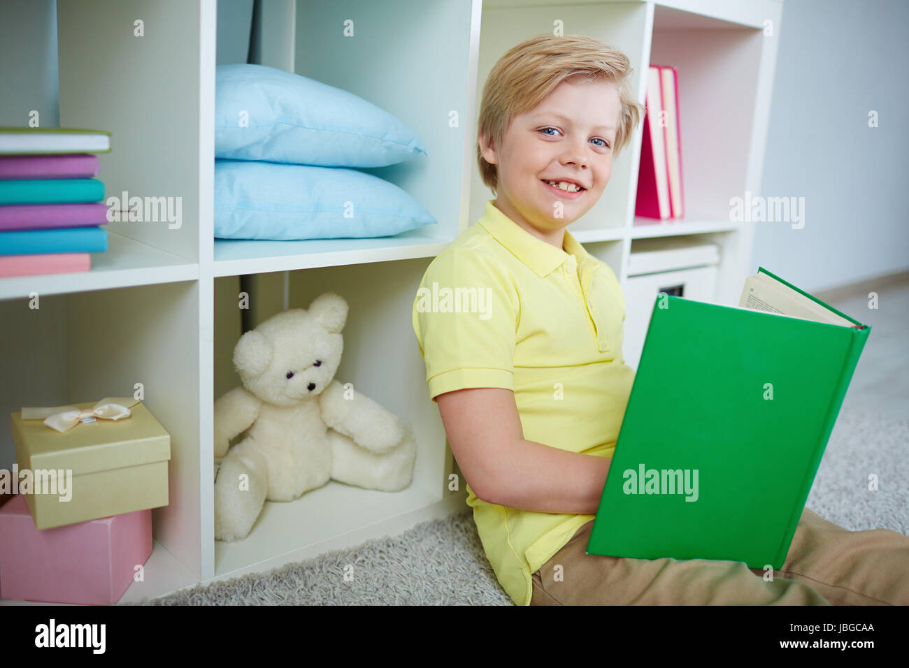 Portrait of clever boy reading book at home Stock Photo - Alamy