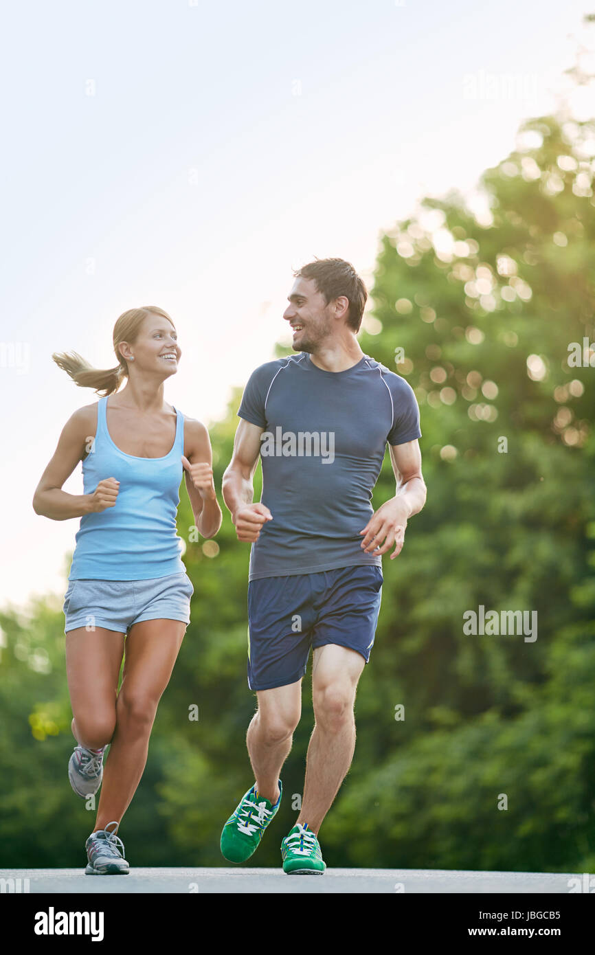 Photo of happy couple running outdoors Stock Photo - Alamy