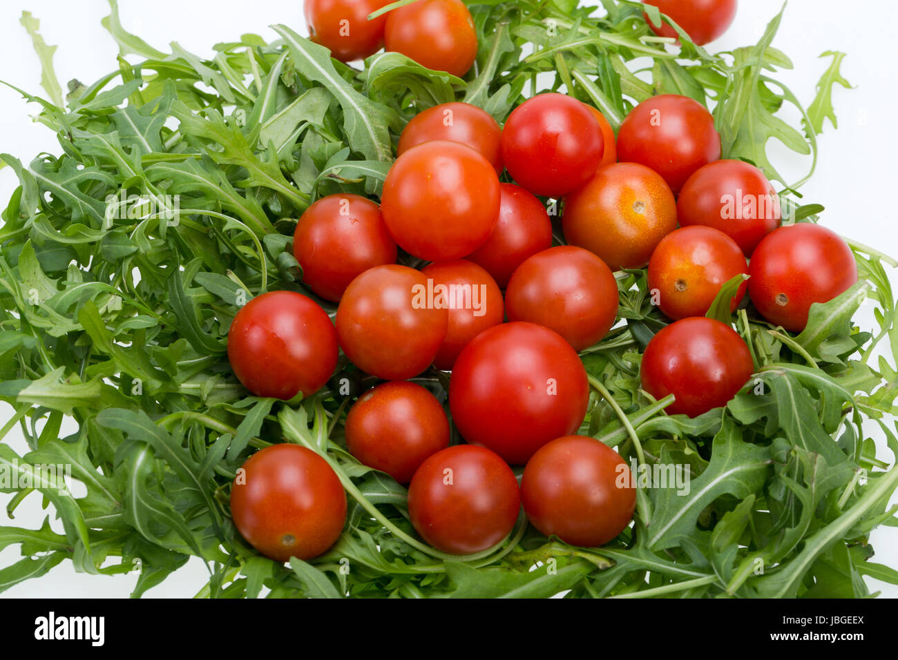 Heap of ruccola leaves and cherry tomatoes Stock Photo - Alamy