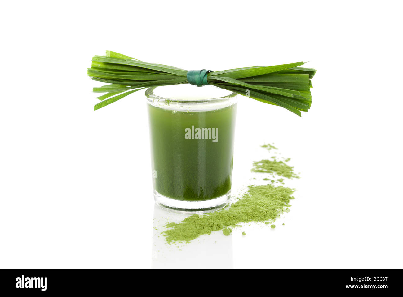 Wheatgrass powder, grass blades and green juice isolated on white ...