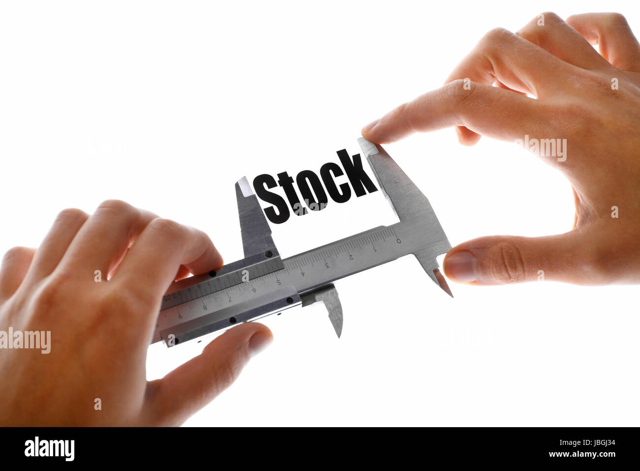 Two hands holding a caliper, measuring the word "Stock Stock Photo - Alamy