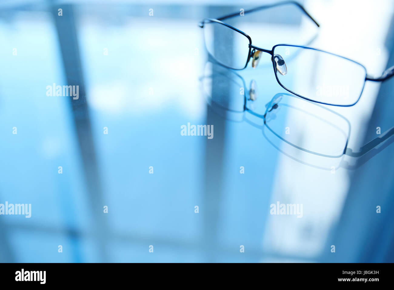 Image of eyeglasses on workplace and its reflection Stock Photo - Alamy