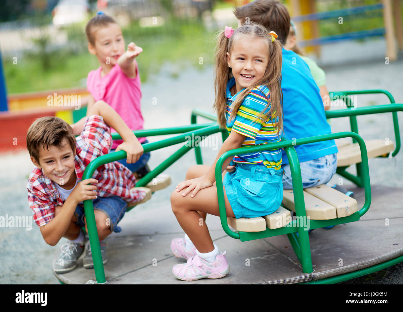 Image of joyful friends having fun on carousel outdoors Stock Photo - Alamy