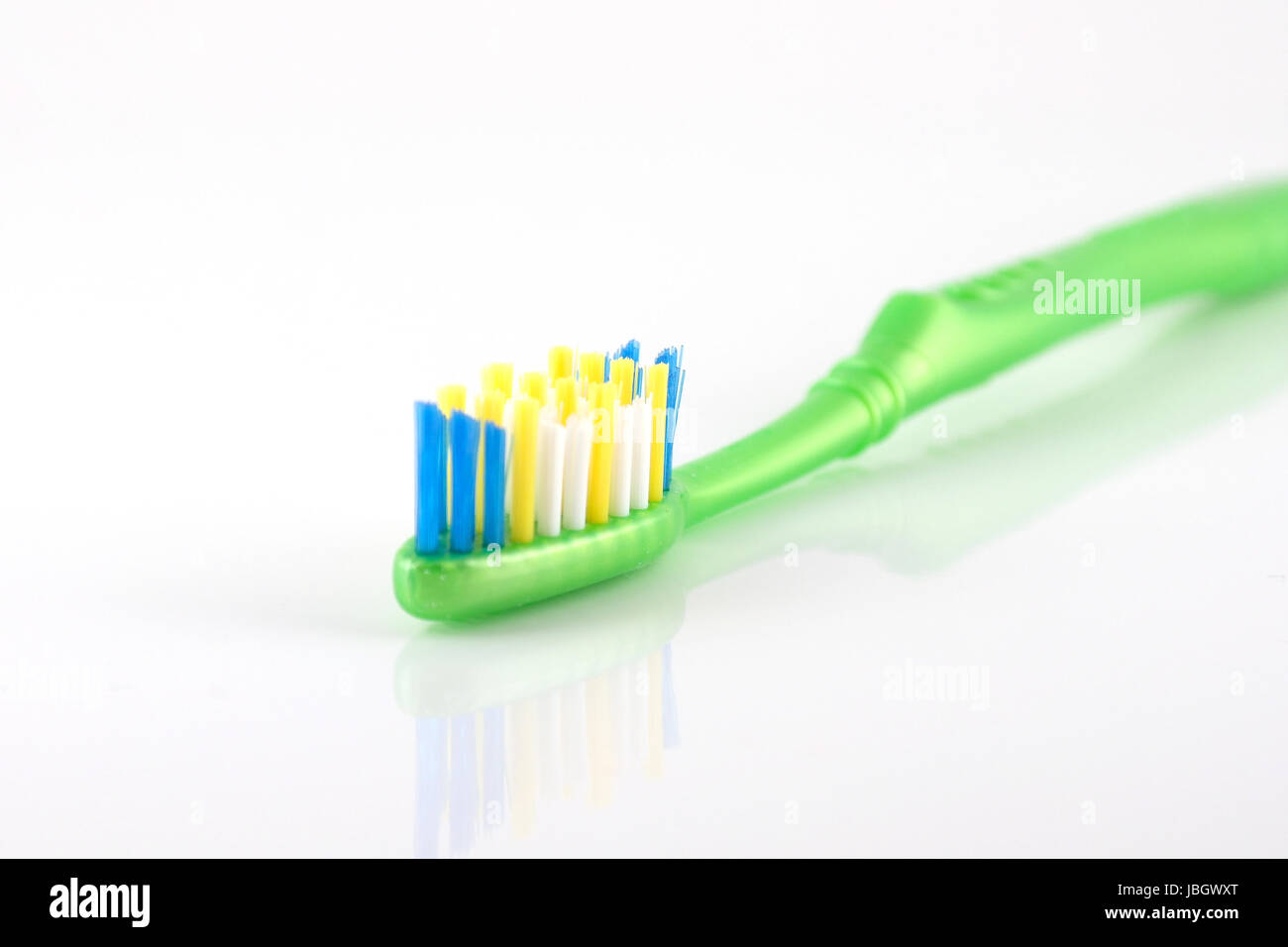 Tooth-brush with green handle over white. Shallow DOF Stock Photo - Alamy