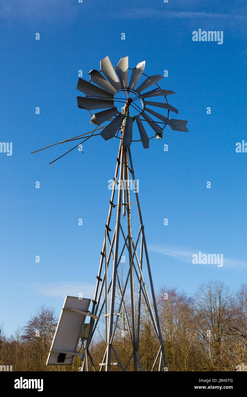 Windmill on a farm in France with blue sky in the background and wild ...